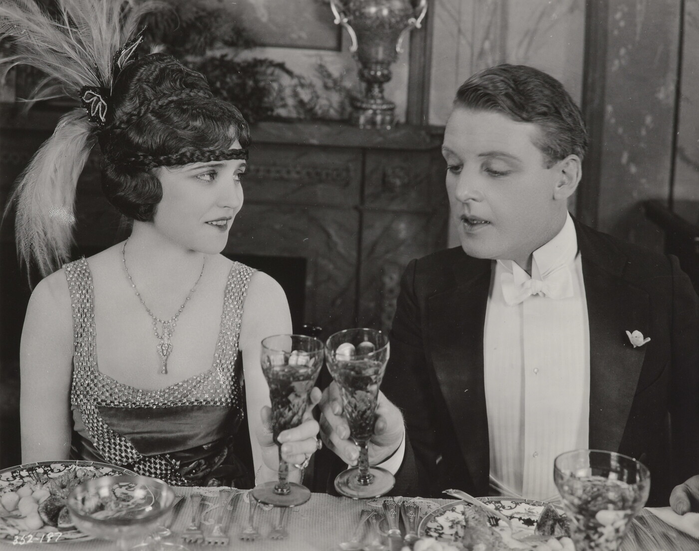 [Agnes Ayres and Forrest Stanley drinking a toast, formal dinner scene ...