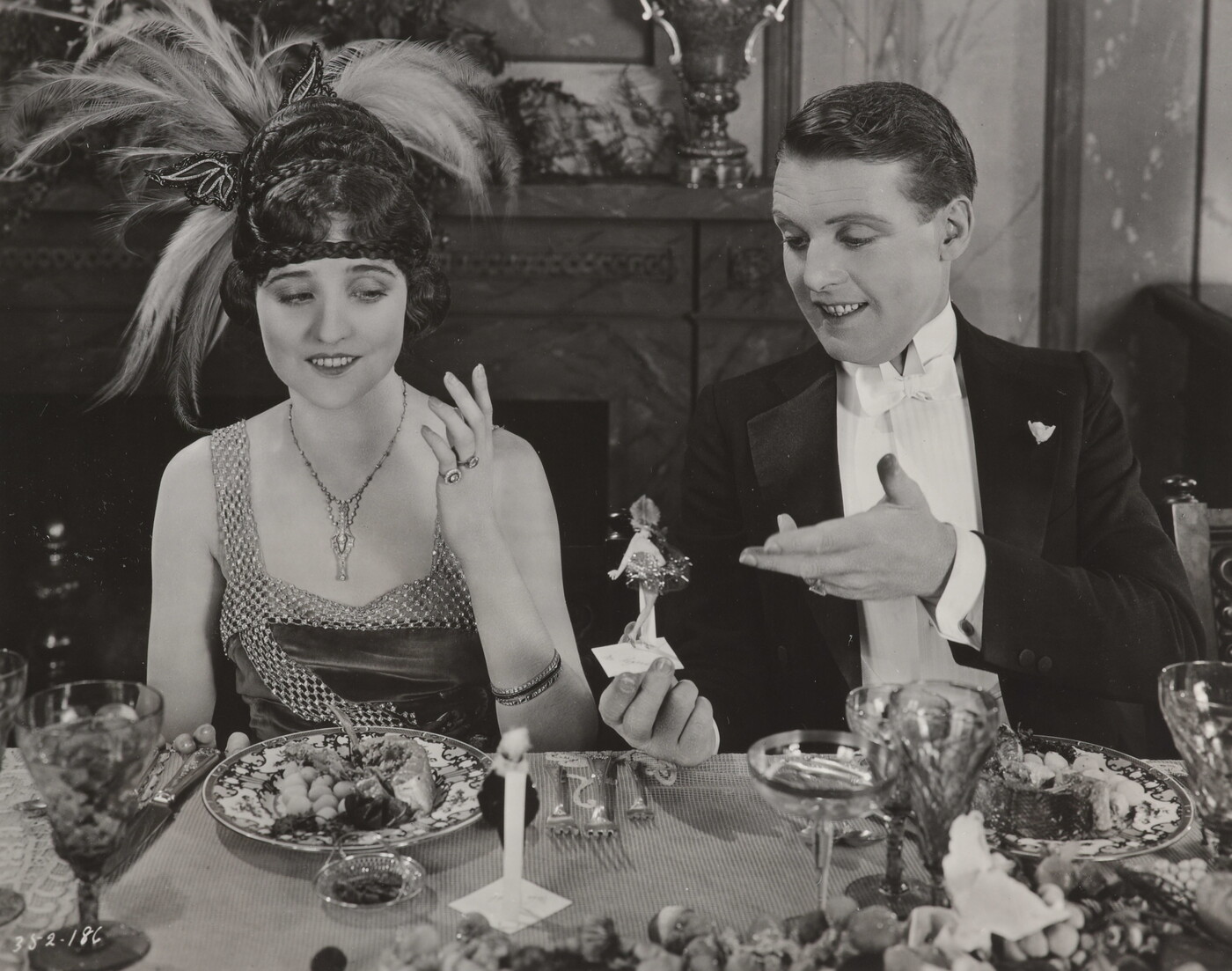 [Forrest Stanley showing figurine to Agnes Ayres, formal dinner scene ...