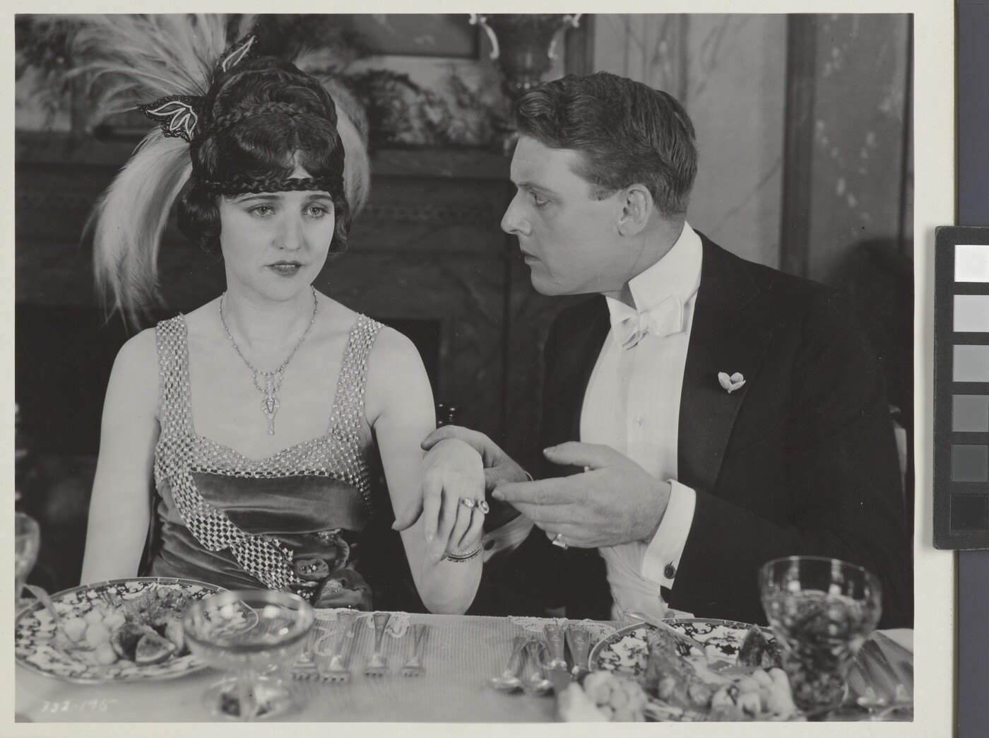 [Forrest Stanley holding Agnes Ayres's wrist in formal dinner scene ...